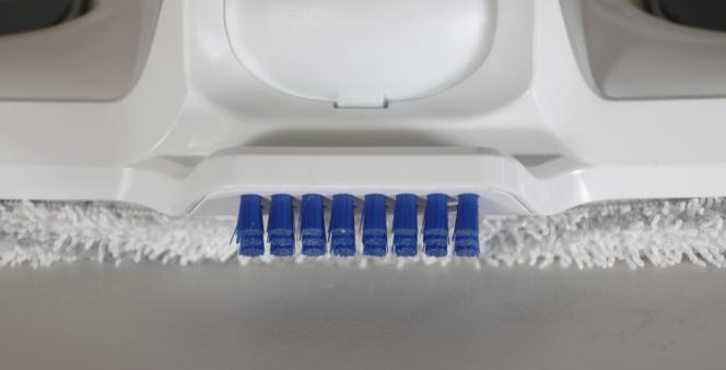 À l’arrière de la tête, une rangée de poils rigides permet de frotter les sols souillés pour faciliter l’élimination de taches très incrustées.