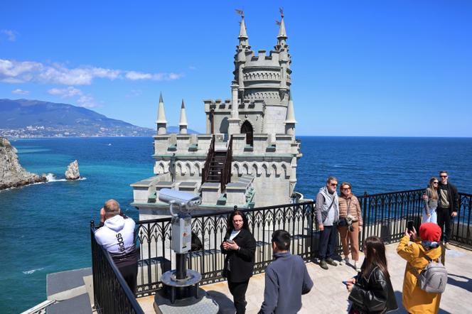 Visitors pose in front of the Swallow's Nest castle near Yalta, Crimea, on April 27, 2025.