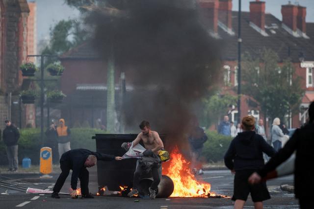 In Belfast, protesters blocked roads and set vehicles on fire after a ...